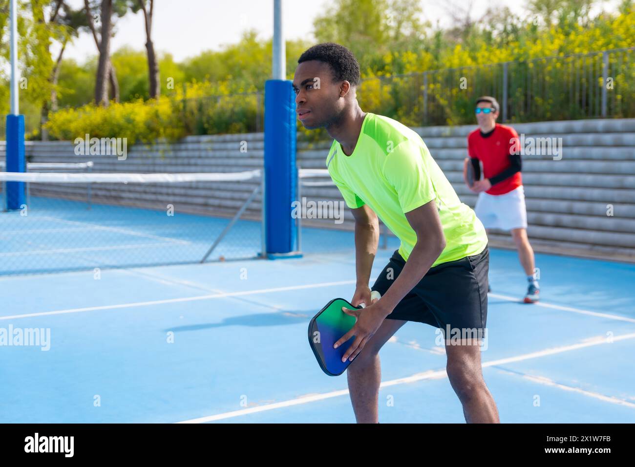 Multi-ethnic friends playing pickleball together in a sunny day in an ...