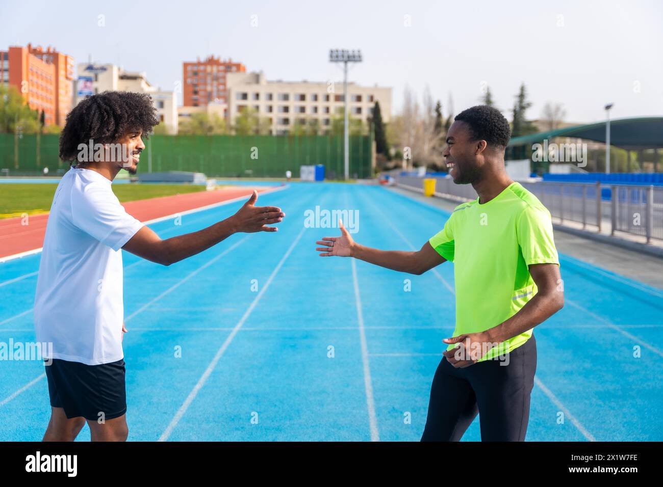 Side view of two african american young happy runners high-fiving in a ...