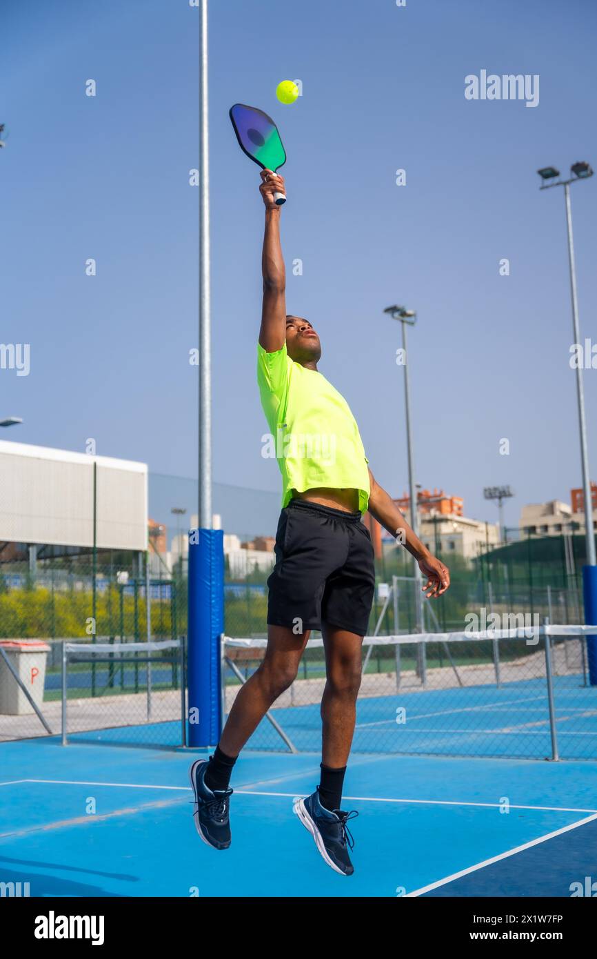 Vertical photo of a young african sportive man jumping playing ...