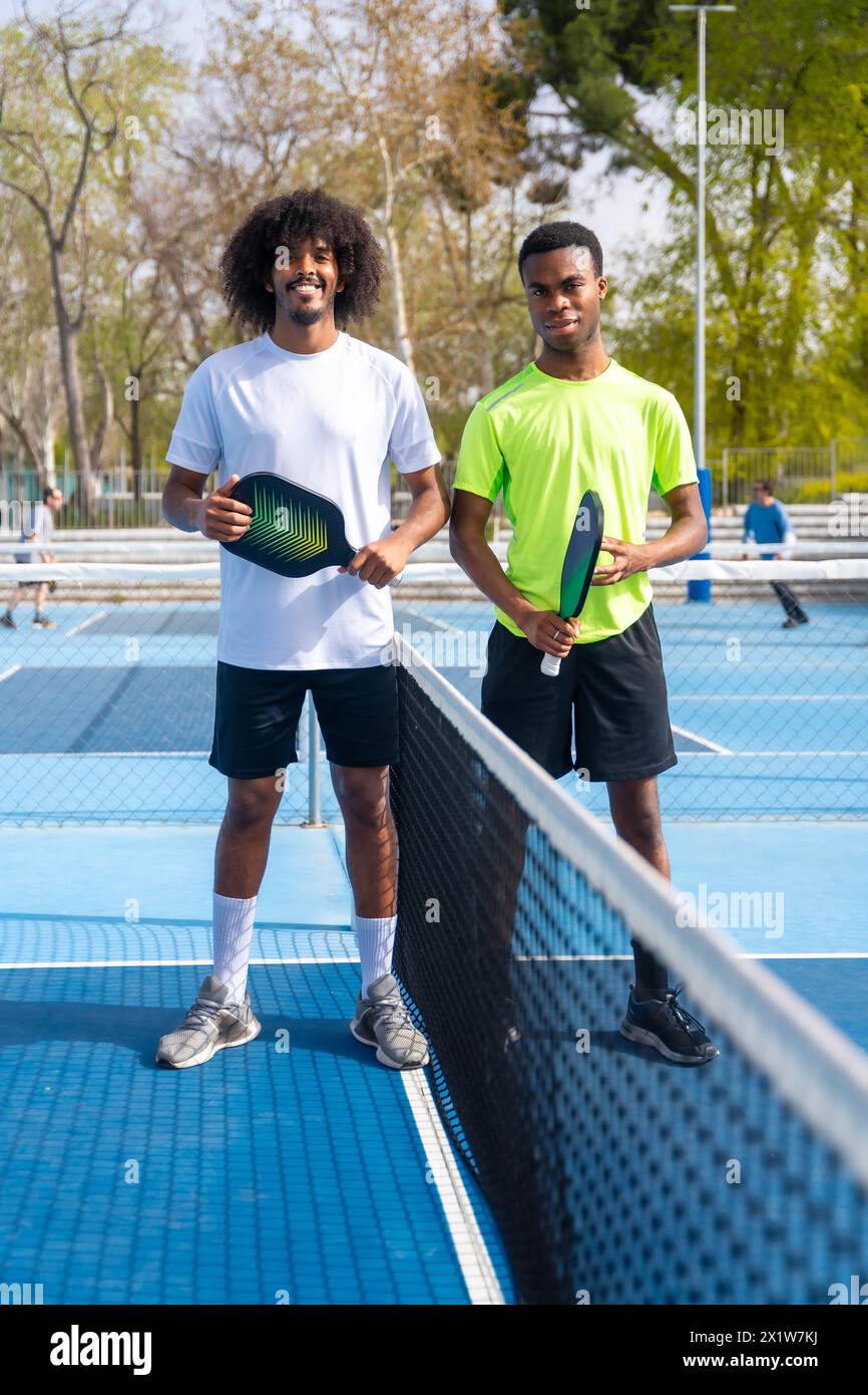 Vertical Portrait of two young african american pickleball players ...