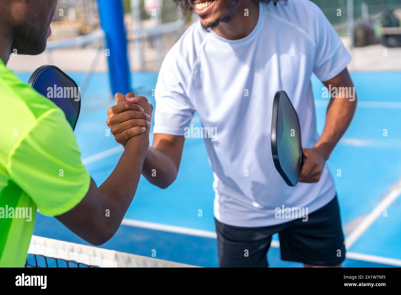 Pickleball african american male rivals shaking hands before playing a ...