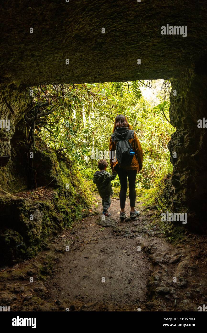A child and his mother in a cave in the Laurisilva forest of Los tilos ...