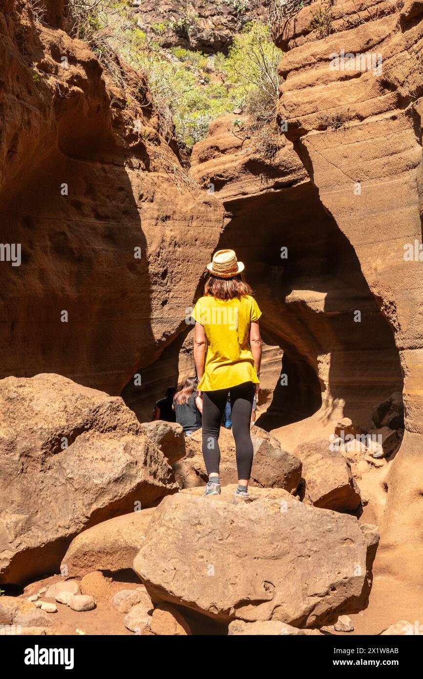 A woman with a hat in the limestone canyon Barranco de las Vacas on ...