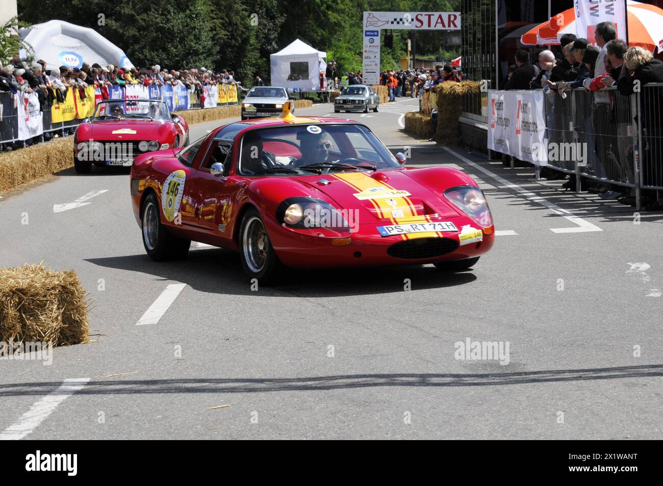 Red Renault sports car drives on a race track with a crowd during the ...