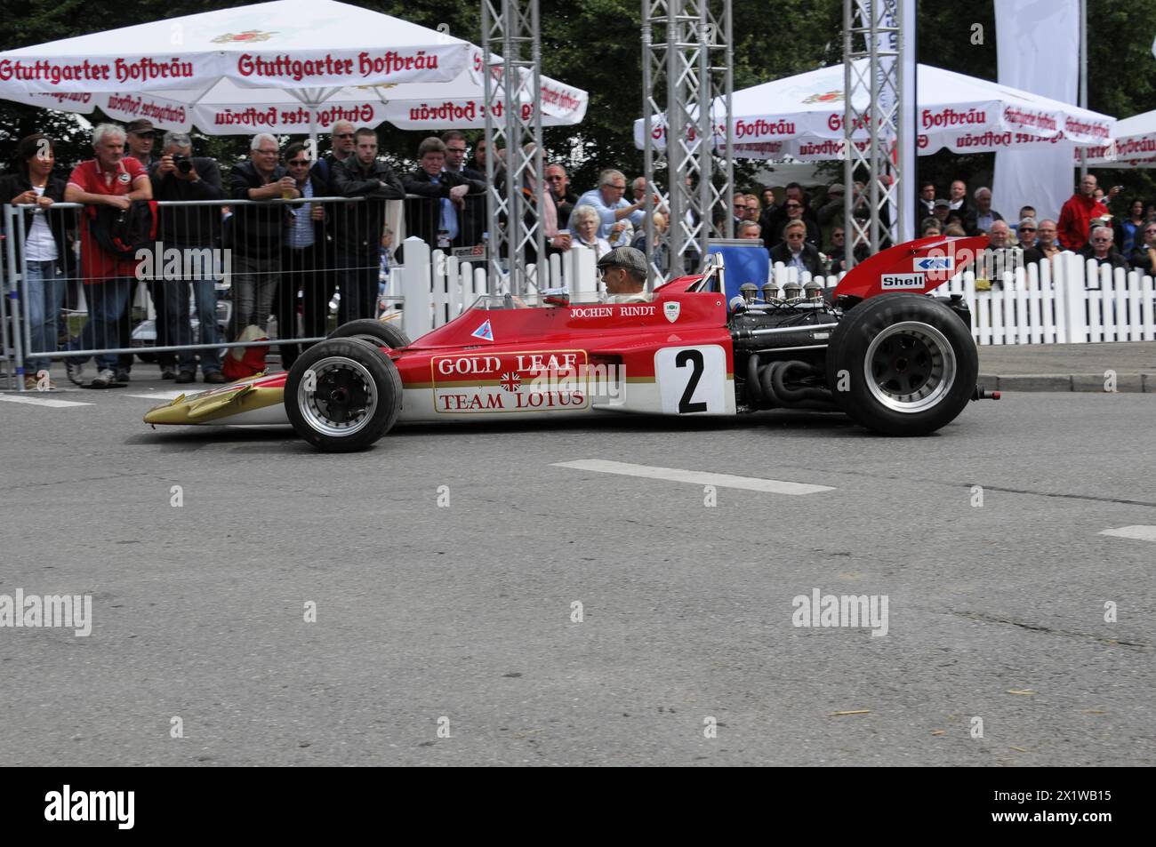 A historic Formula 1 racing car drives past a crowd at a motorsport ...