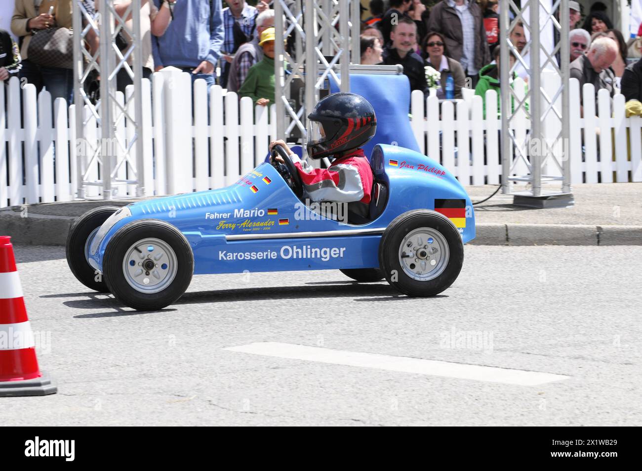 Driver in a blue racing soapbox skilfully manoeuvres on the race track ...