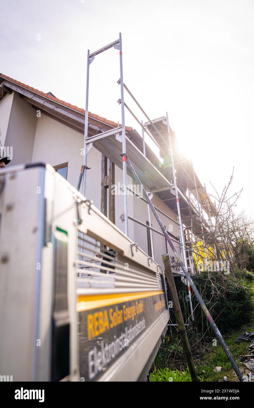 A scaffold with ladder stands on a house in the sunlight, solar systems ...