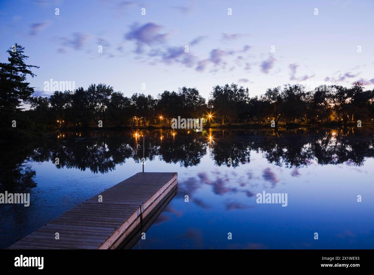 Wooden dock floating on calm surface of Mille-Iles river and view of ...