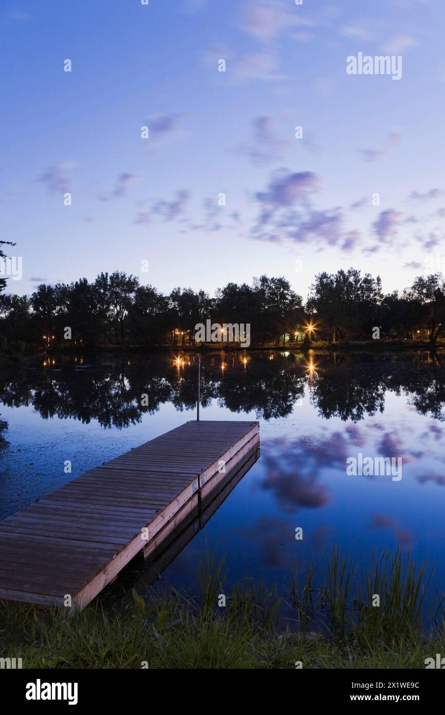 Wooden dock floating on calm surface of Mille-Iles river and view of ...
