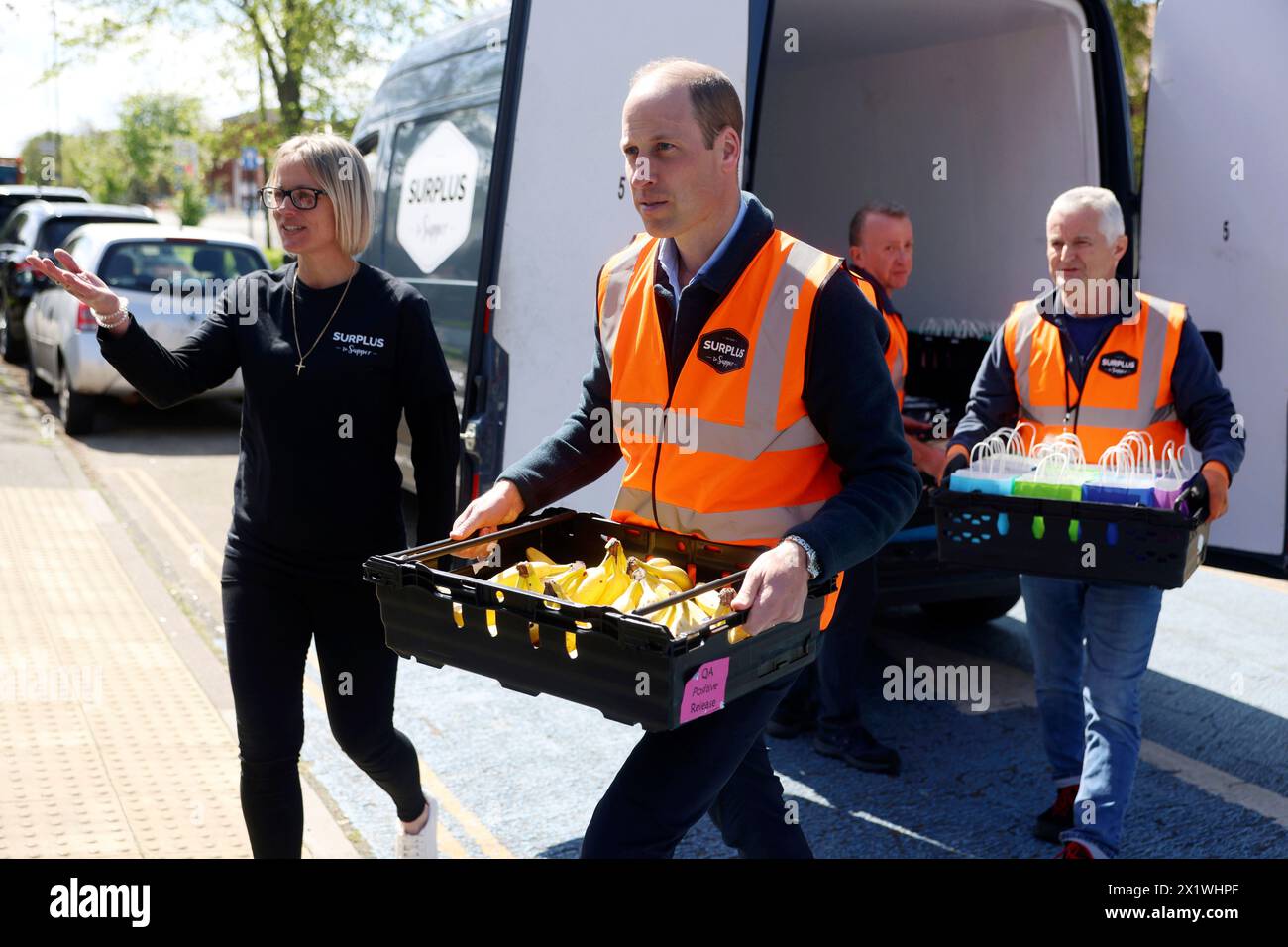 Britain's Prince William, center, carries a crate of bananas as he ...