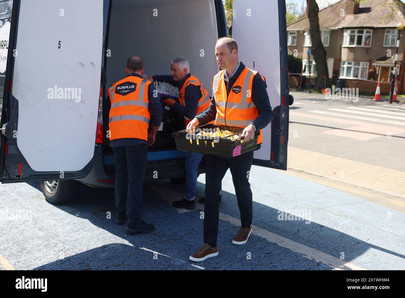 Britain's Prince William, center, carries a crate of bananas as he ...