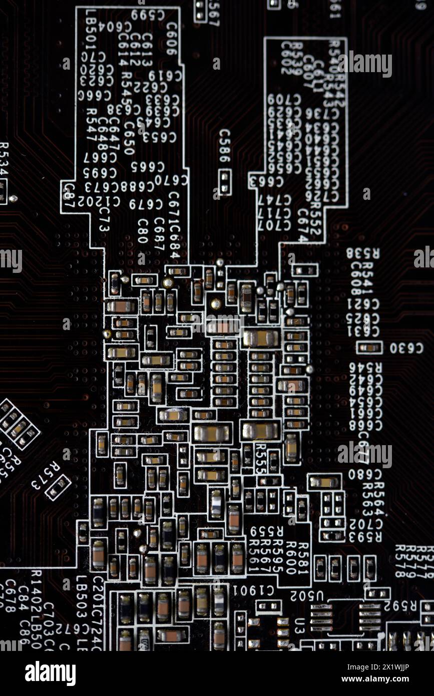 A brown printed circuit board with resistors and capacitors. An ...