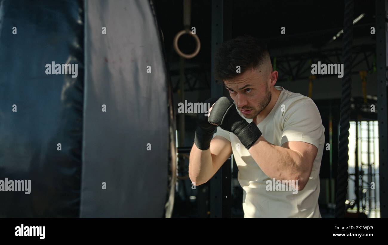 Male sportsman Caucasian man boxer training with punching bag boxing ...
