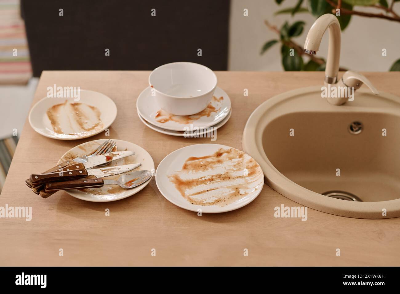 Several dirty plates, knives, porcelain bowl, steel spoon and fork ...