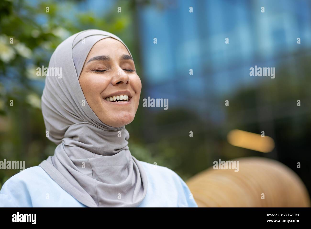 An image of a joyful Muslim woman wearing a hijab, laughing heartily ...