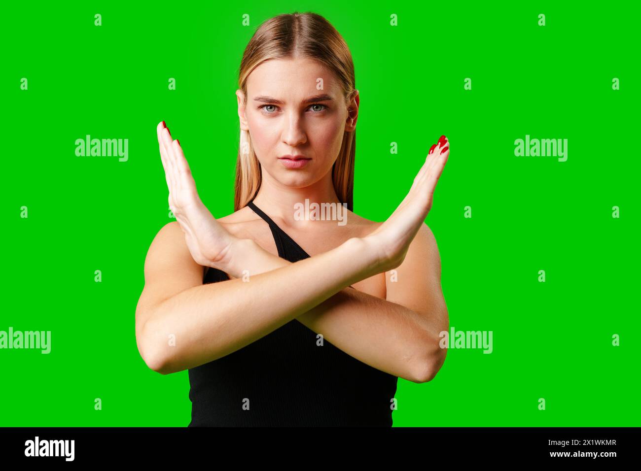 Young Woman Making Stop Sign Gesture on green background Stock Photo ...