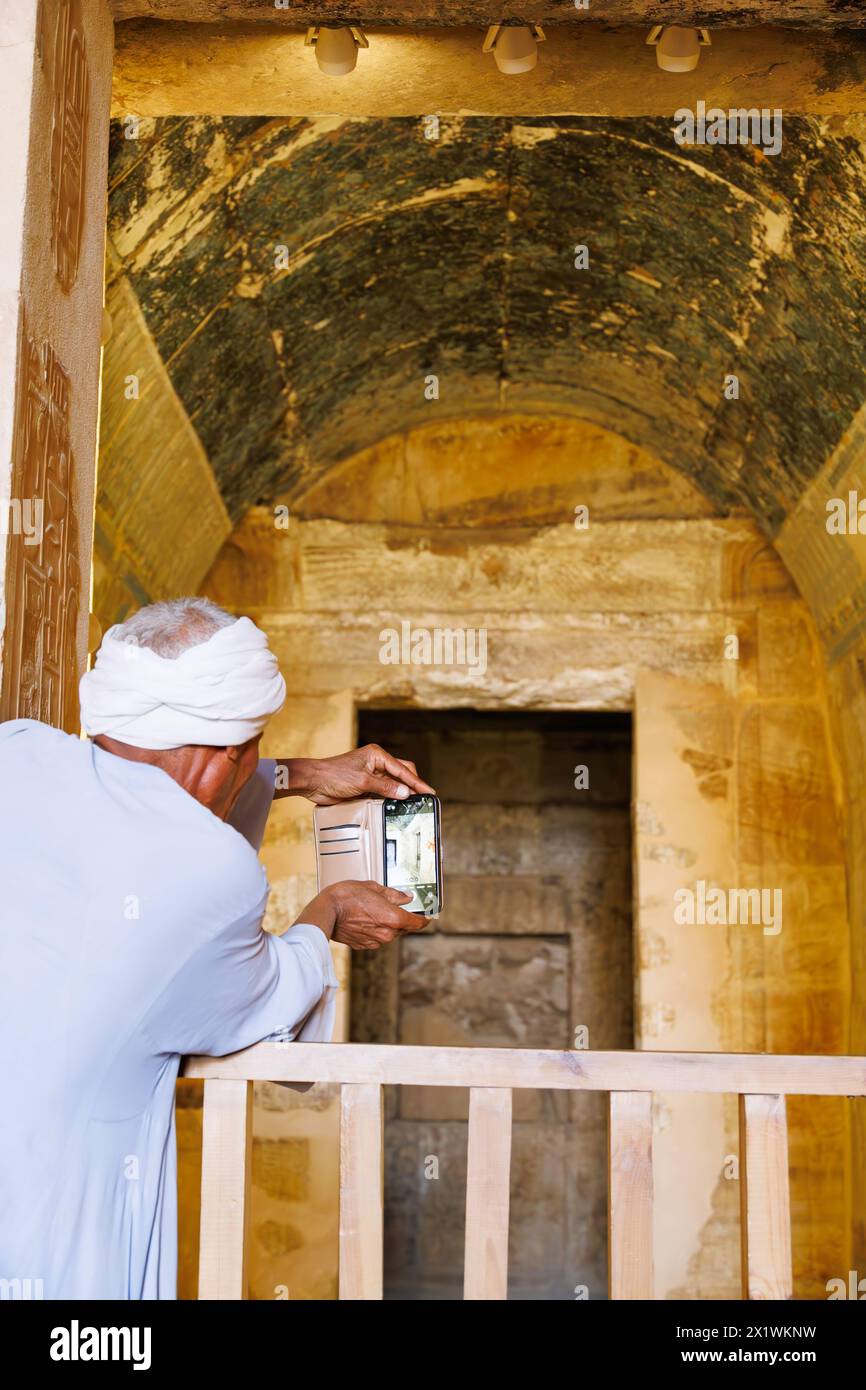 Local Egyptian guide take a photo on a mobile smart phone for a tourist ...