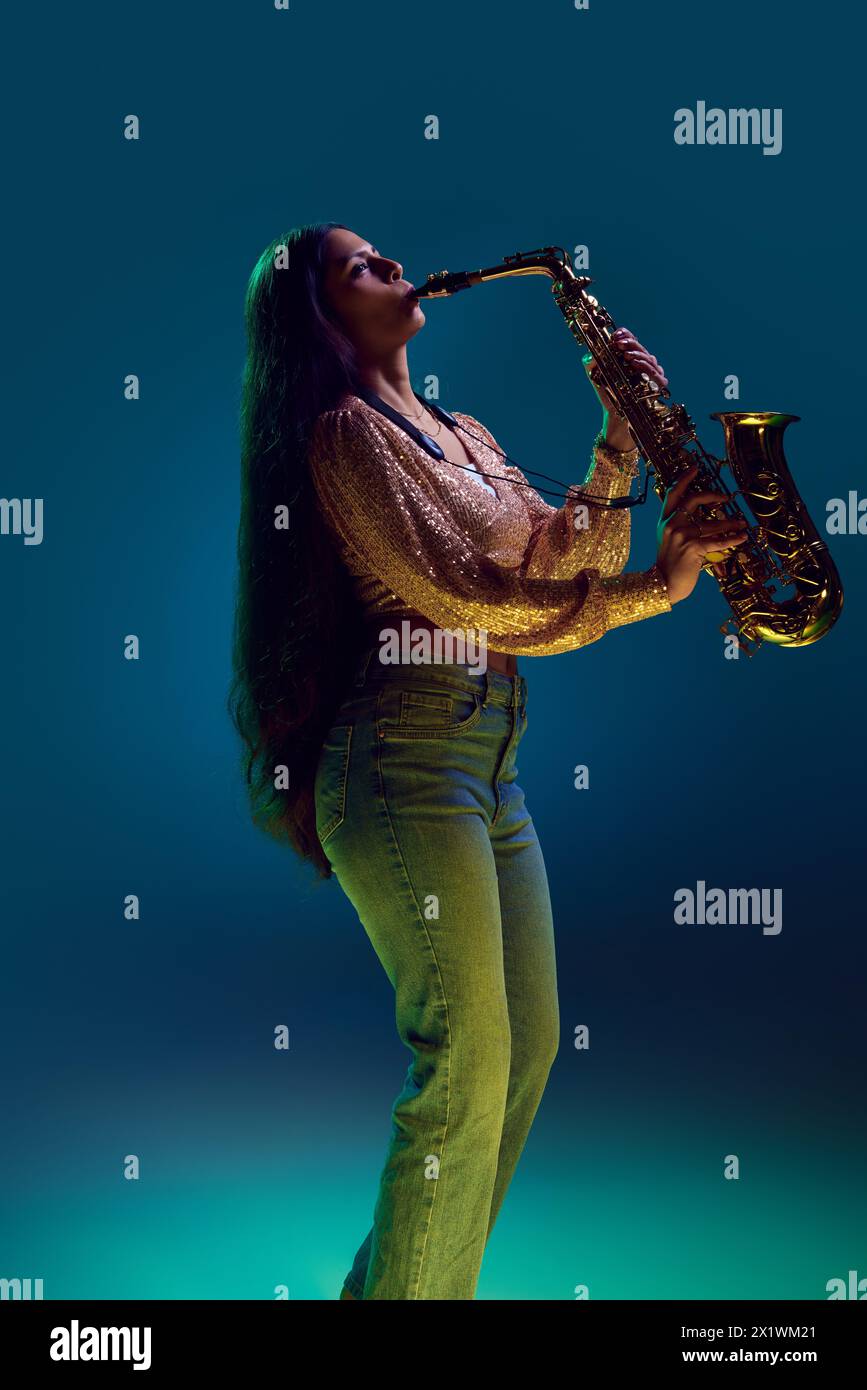 Side view photo of Indian woman, saxophonist performing solo in neon ...