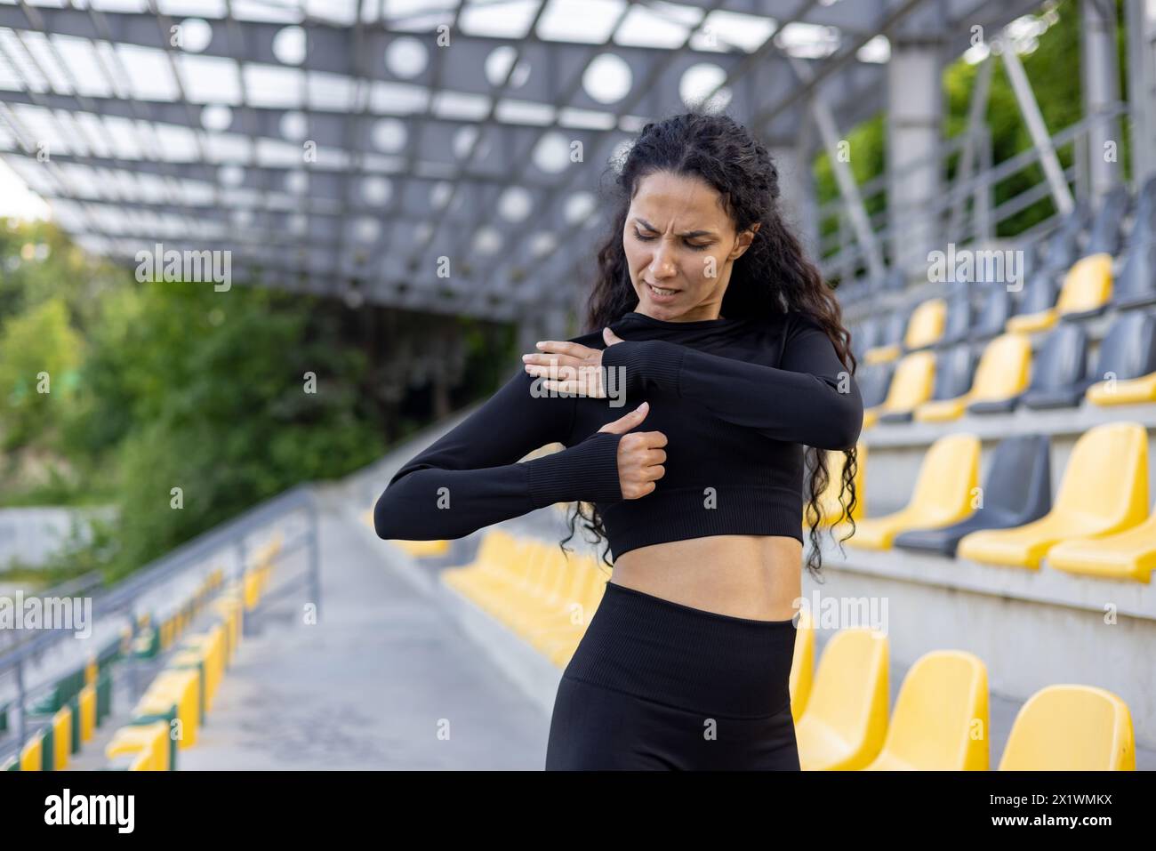 A hispanic woman experiences sharp pain in her shoulder while ...