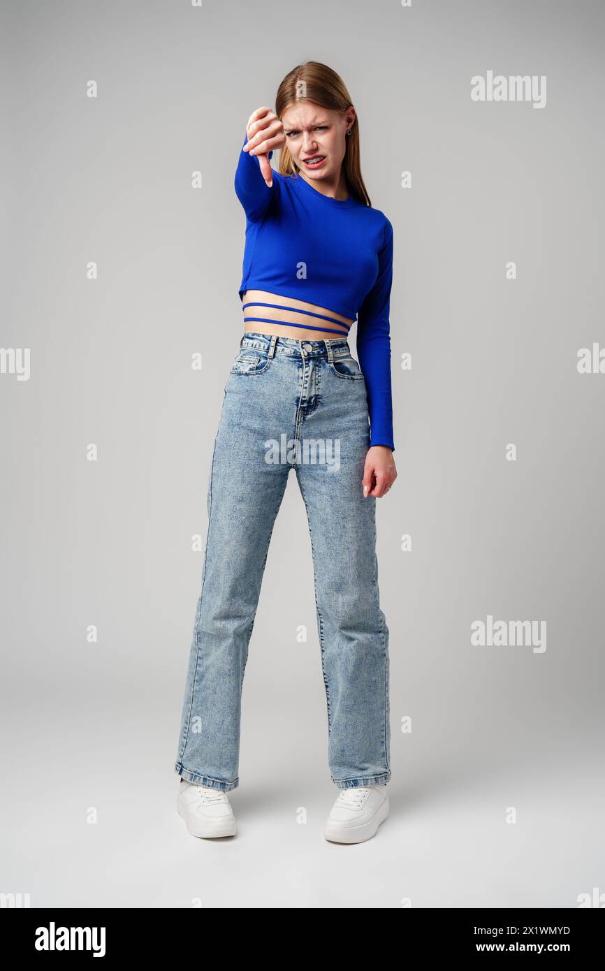 Young Woman Pointing Finger Down at Camera in studio Stock Photo - Alamy