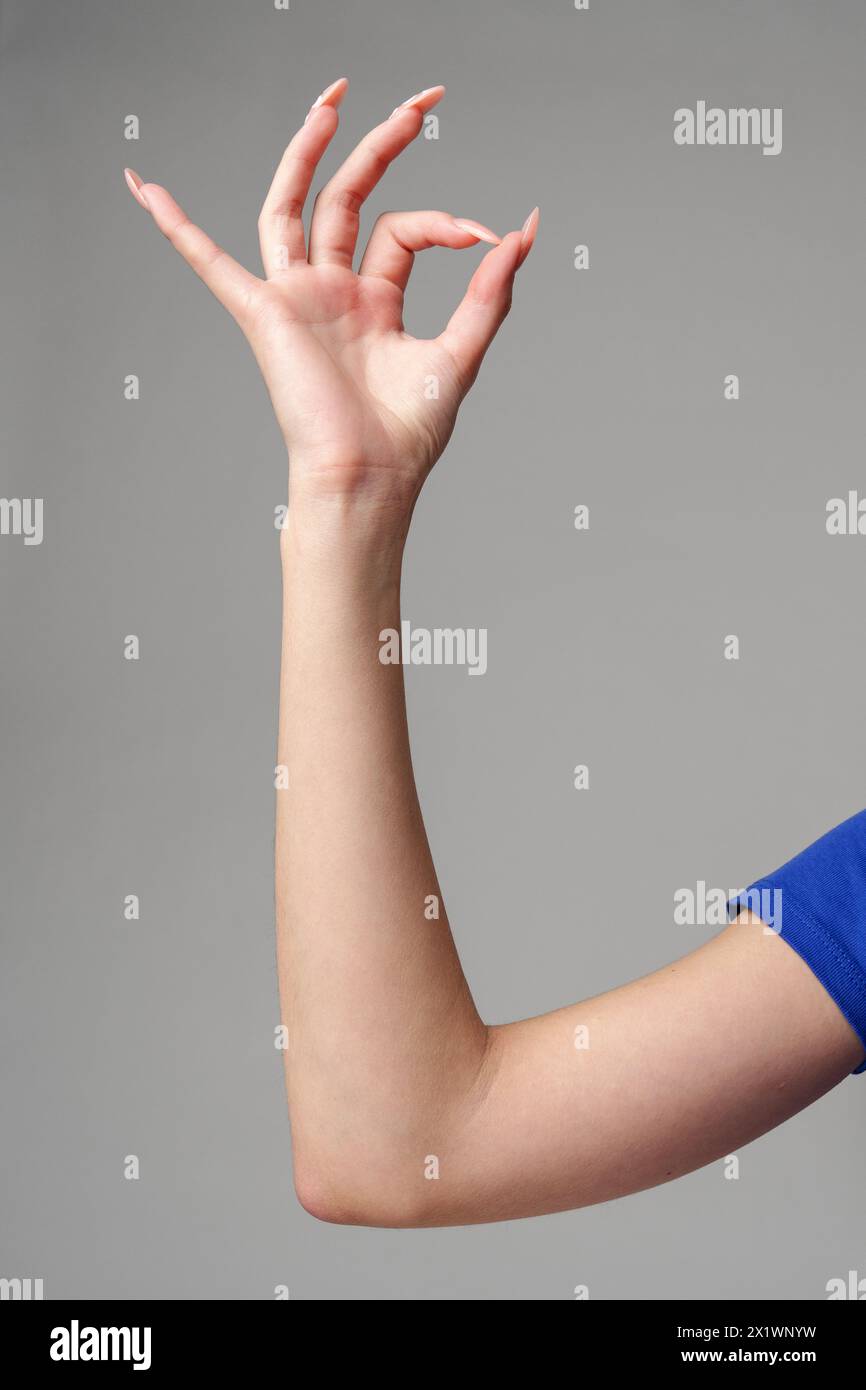 Female hand sign against gray background in studio Stock Photo - Alamy