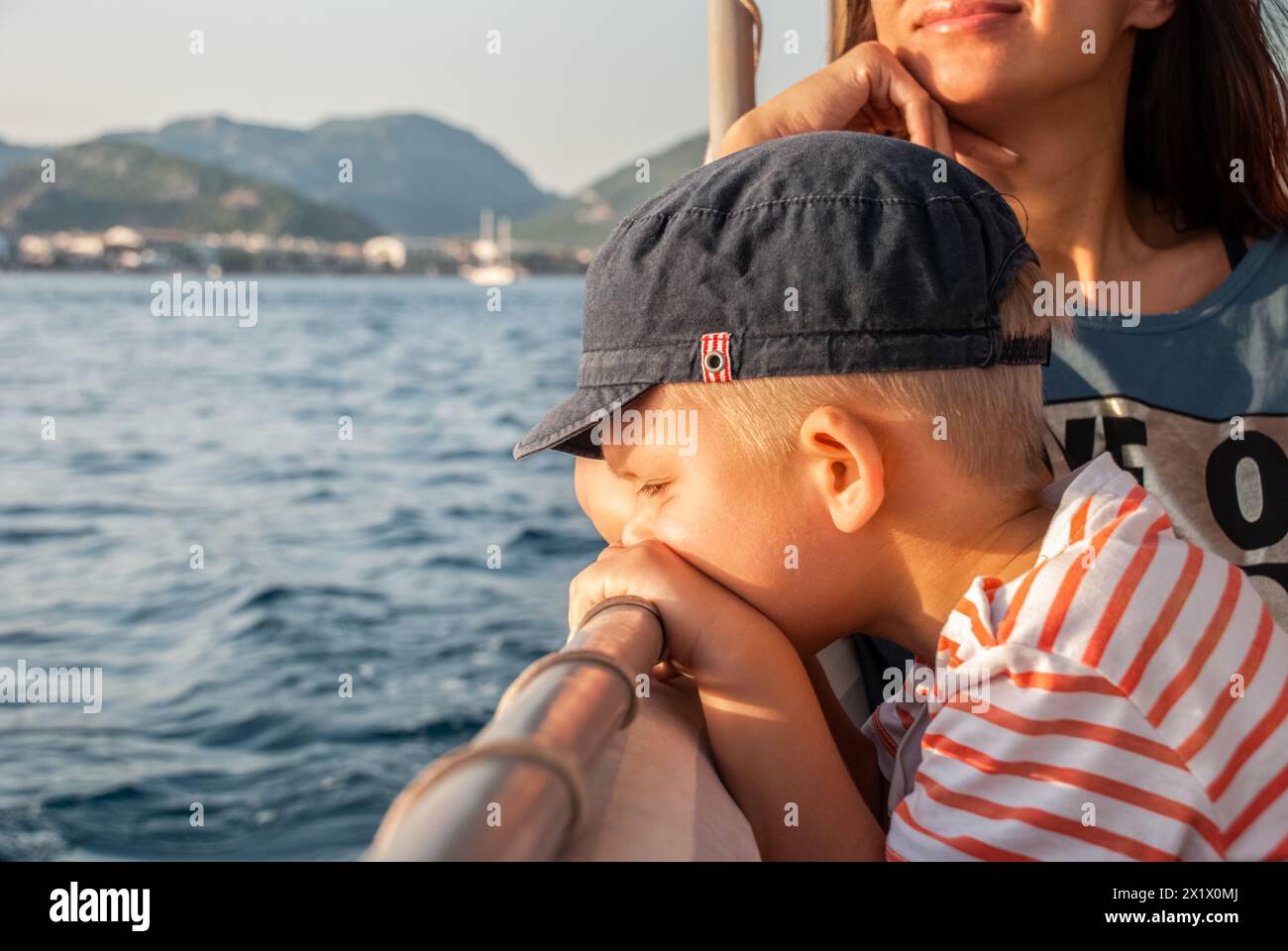 Cute toddler with mother enjoys boat trip sailing in sea past coast of ...