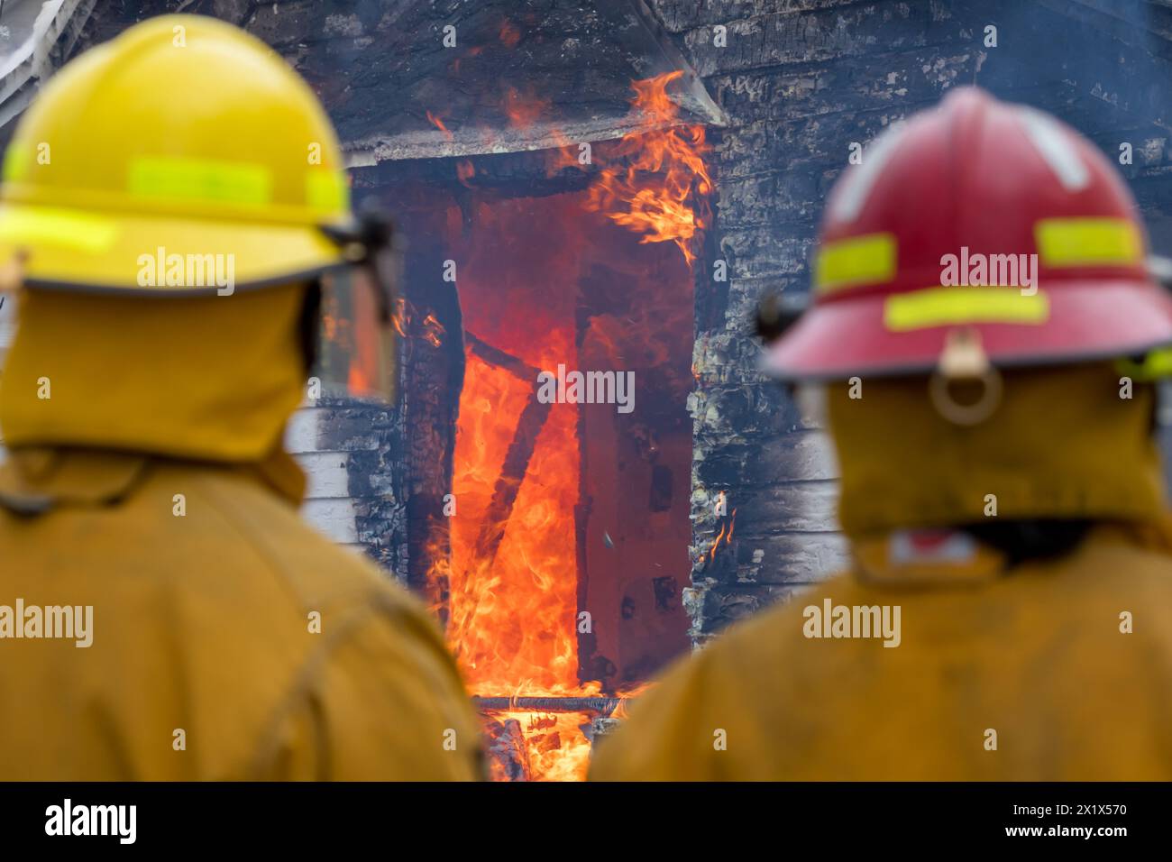 two unidentified firefighters watching a fire Stock Photo - Alamy