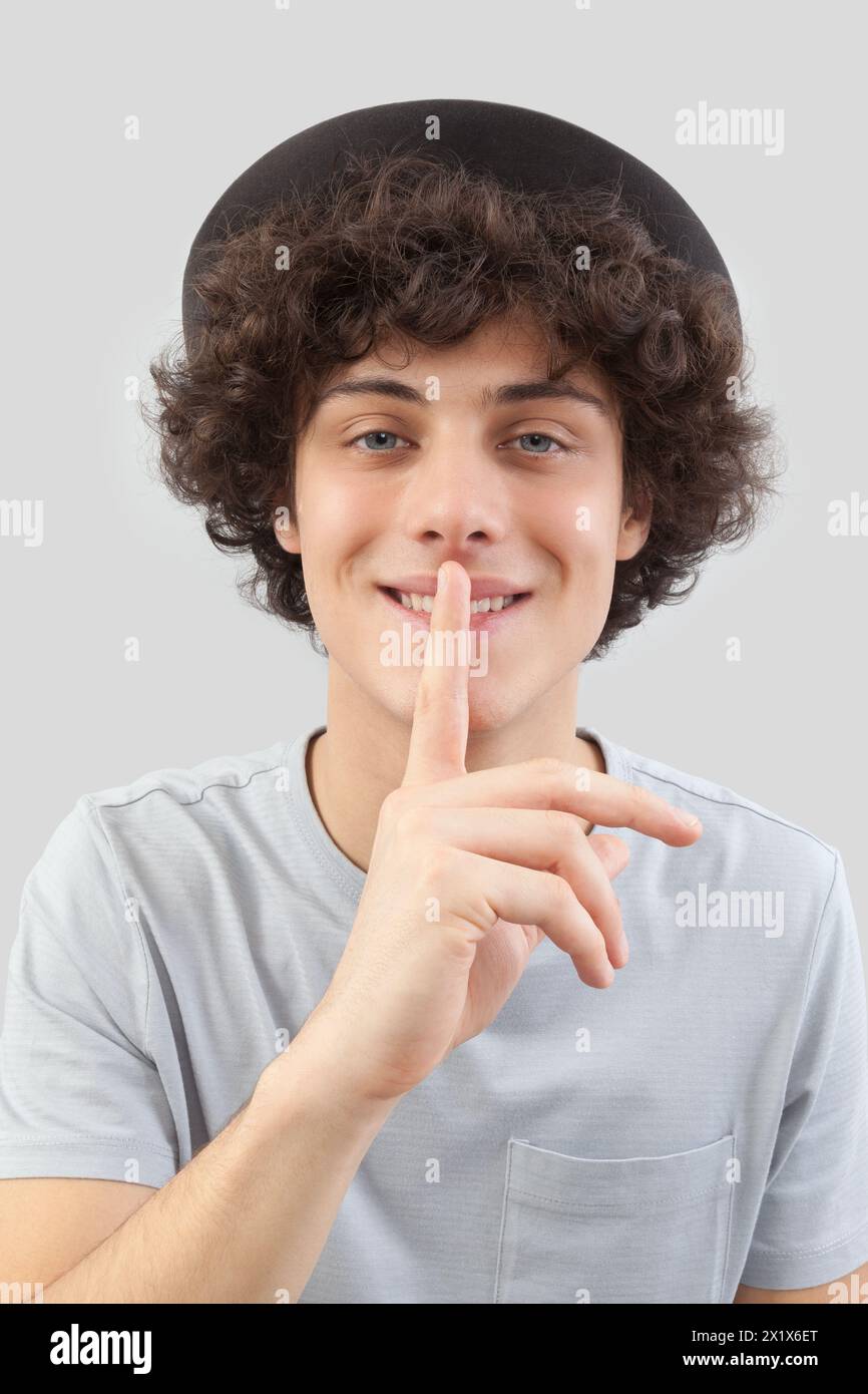 Smiling and handsome, the young man with blue eyes wears a hat and ...