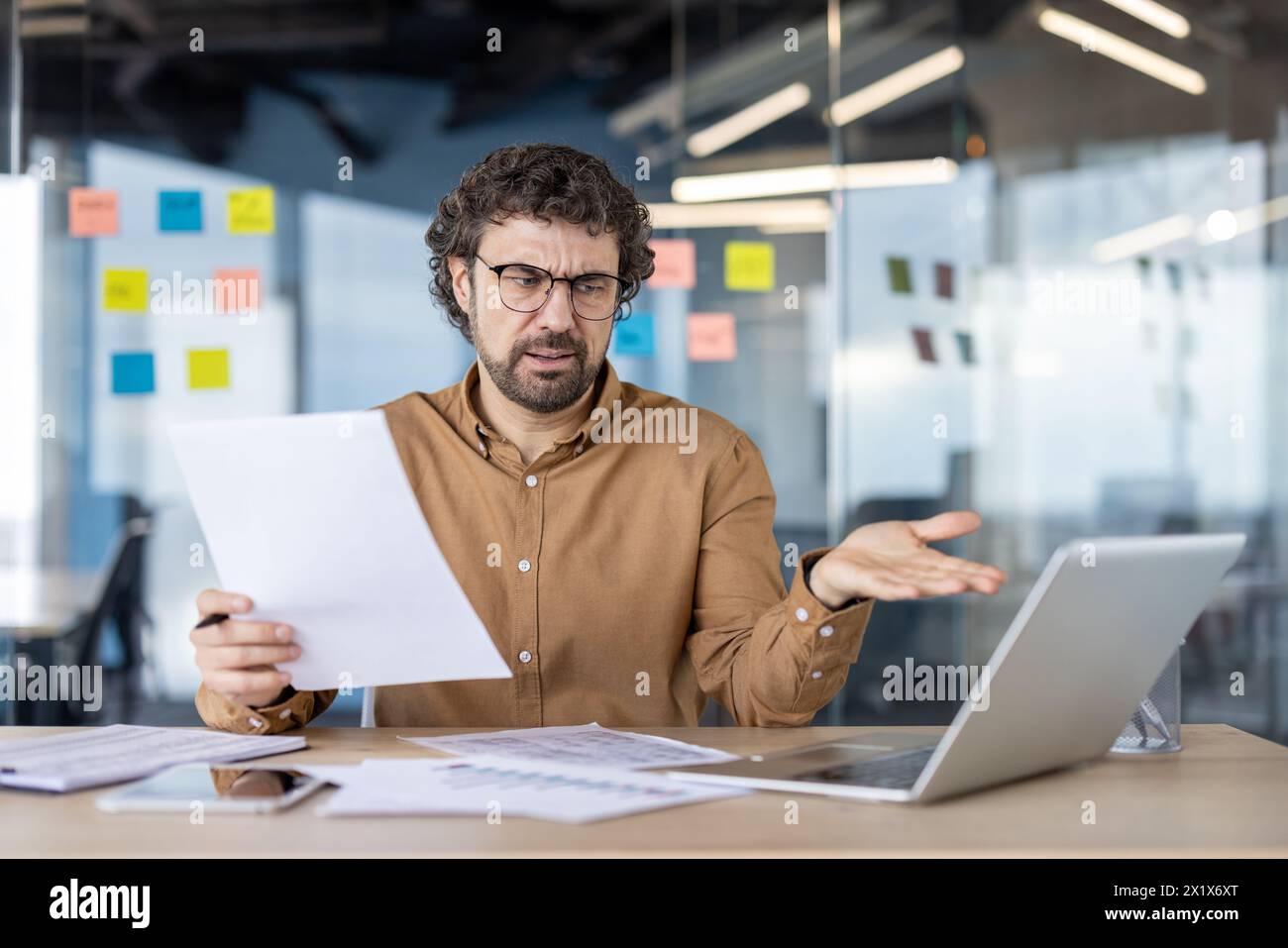 Stressed man wearing sandy shirt to office and stretching hand to ...