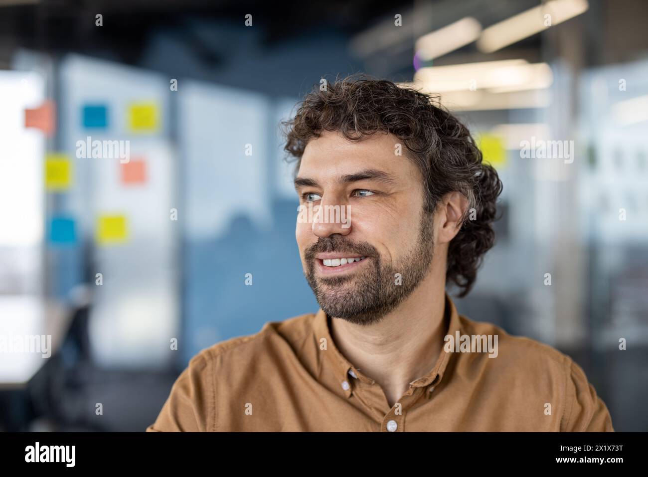 Portrait of startup creator looking aside with friendly smile on ...