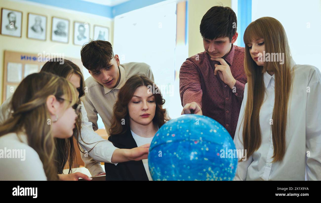 Students look at a globe of the starry sky in a classroom at school ...