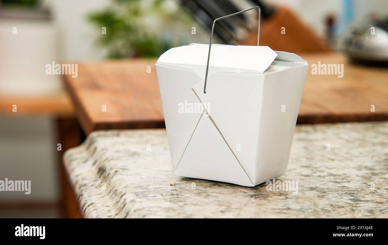 A close-up view of a white Chinese takeout box, featuring the iconic ...