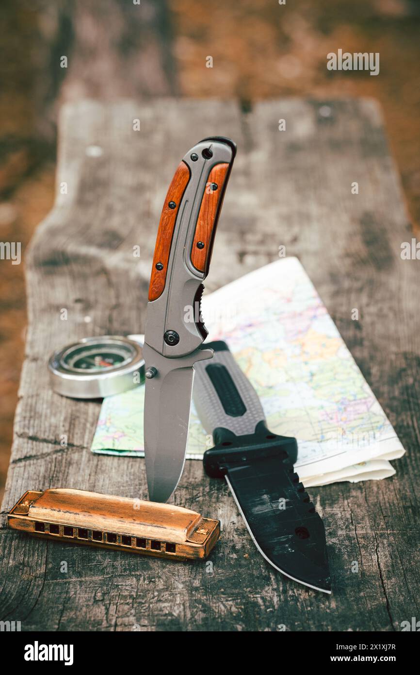 Knife with a harmonica and a map on a wooden background Stock Photo - Alamy