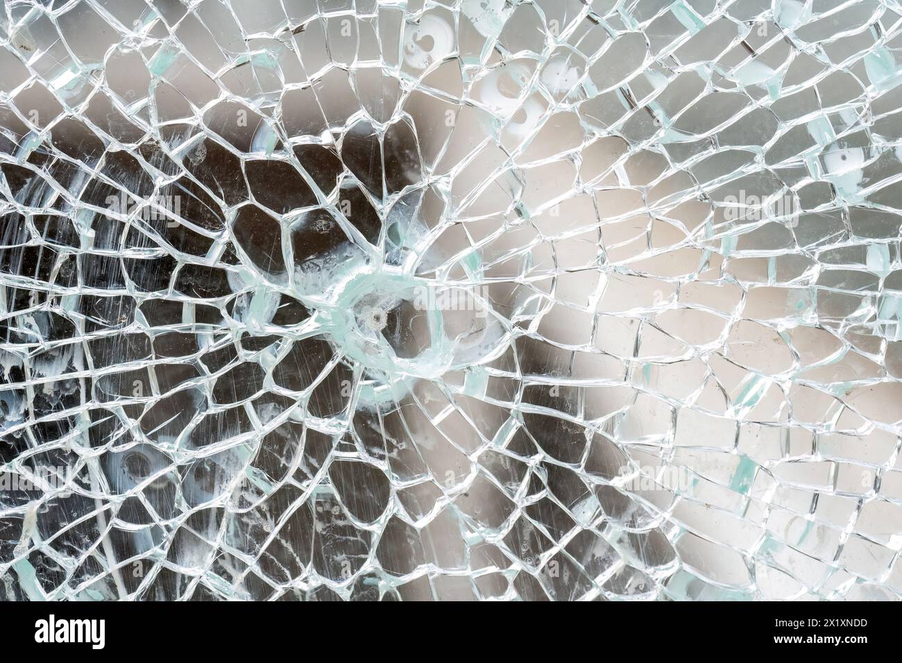 Closeup detail macro view of cracks spreading across a shattered glass ...