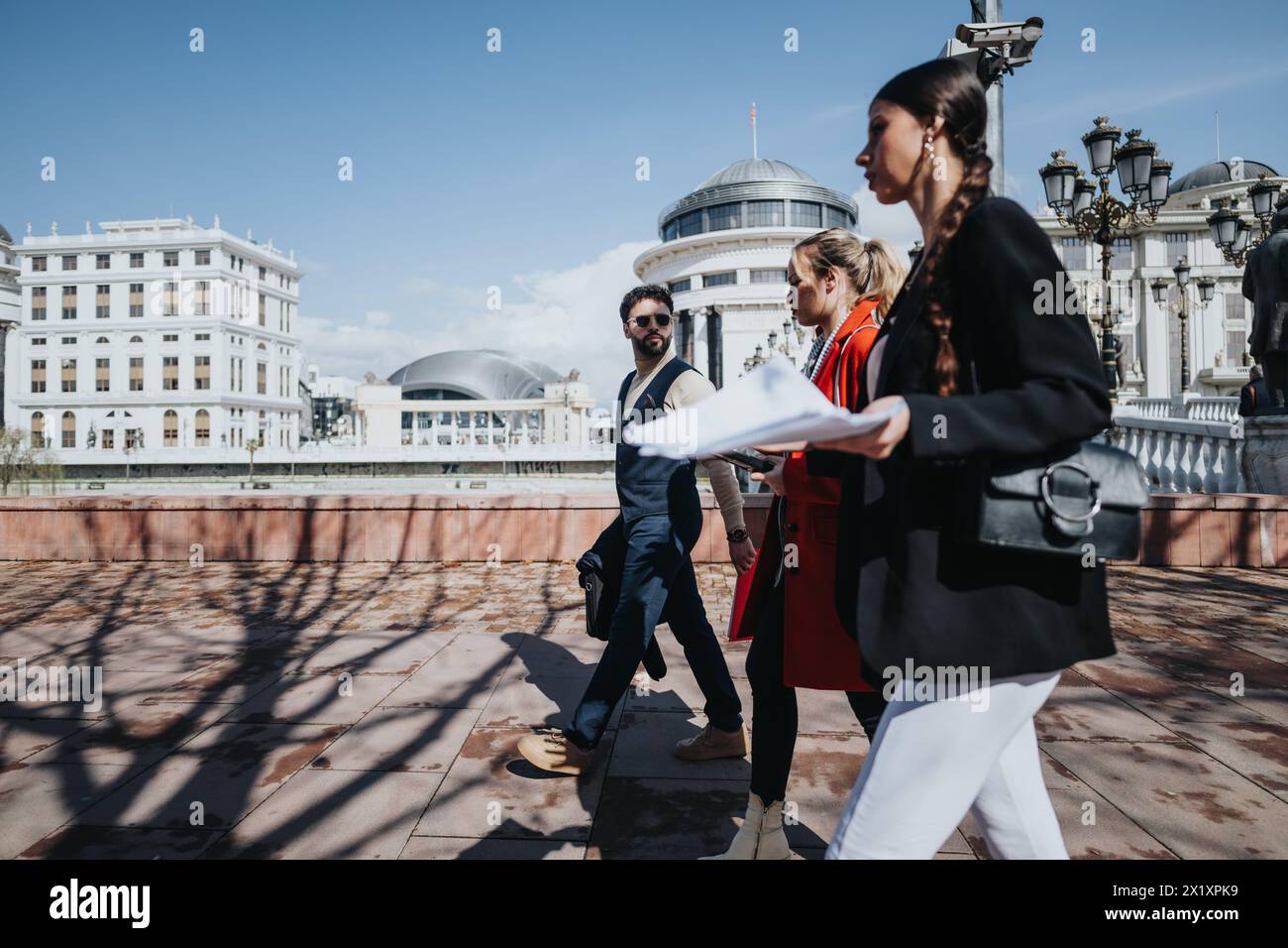 Young professionals discussing business strategy in an outdoor urban ...