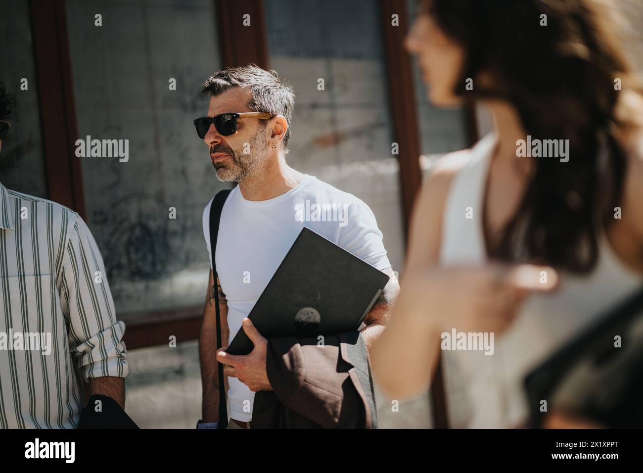 Cross-generational business executives discussing outdoors in the city ...