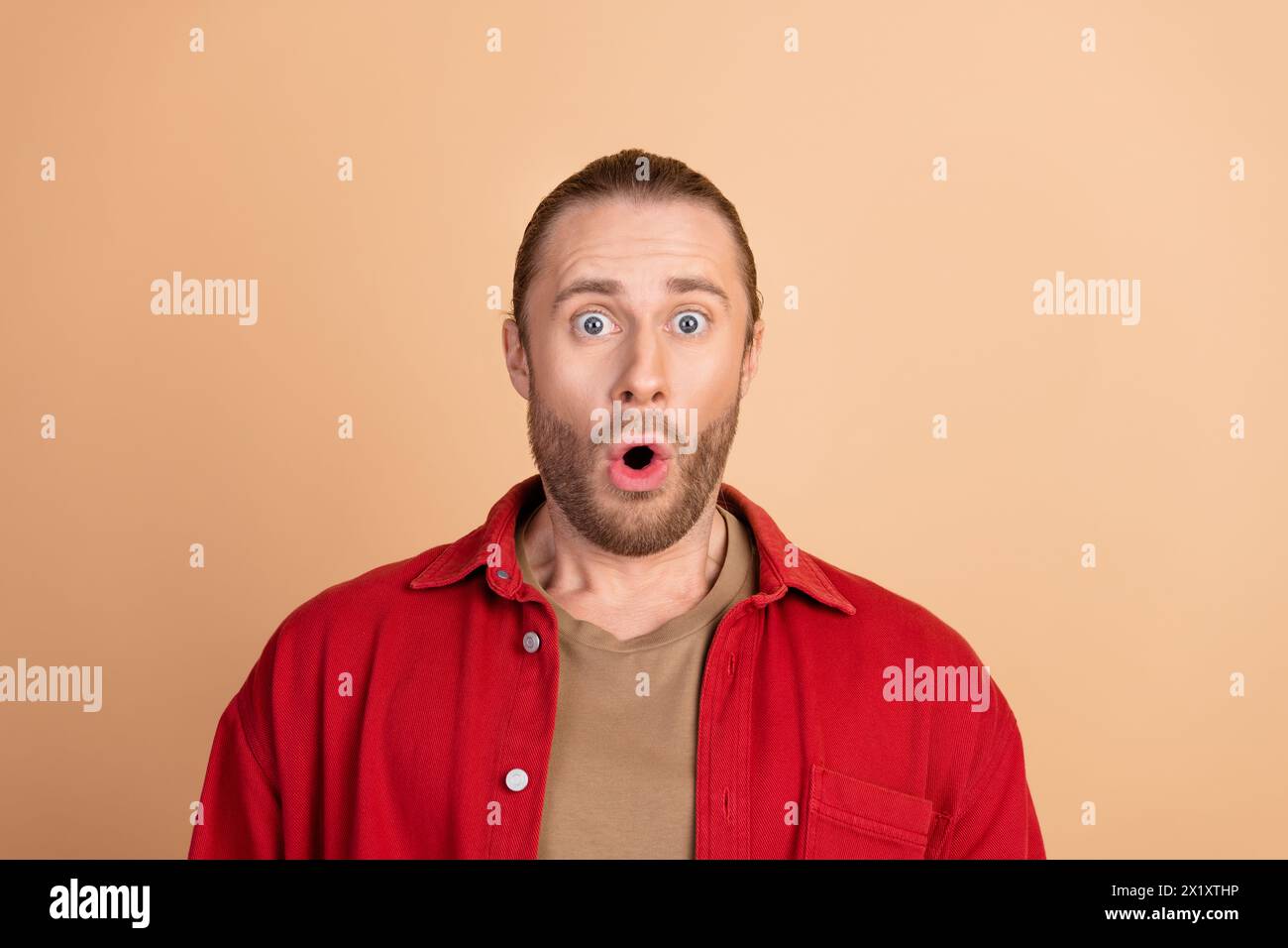 Portrait of nice young man open mouth stare wear red shirt isolated on ...