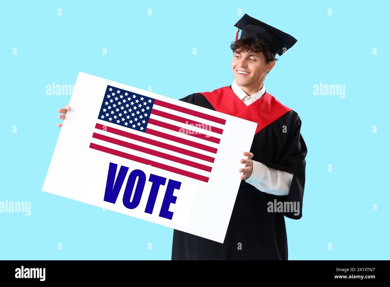 Male graduating student holding poster with word VOTE and USA flag on ...