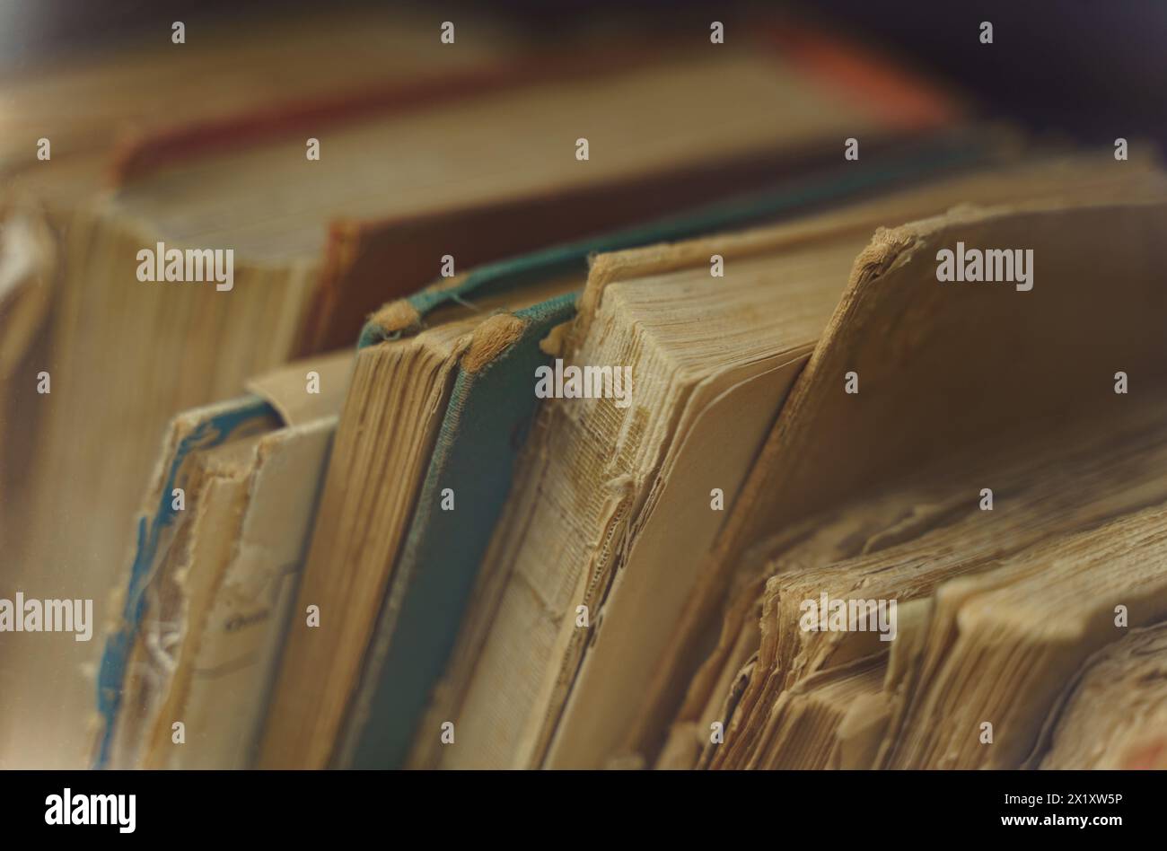 Old books stand in a row on the showcase. Close-up. background image ...