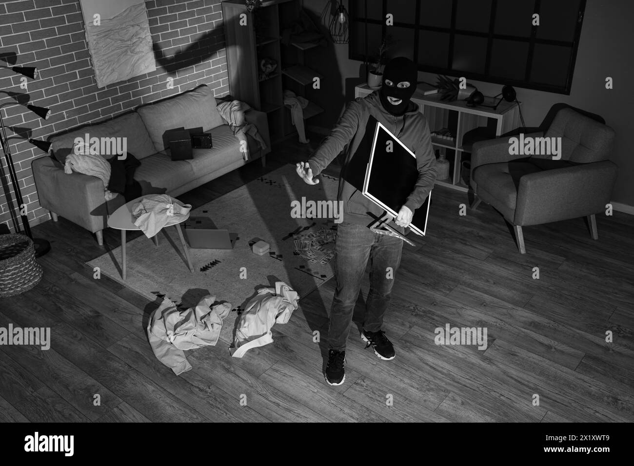 Male thief stealing monitor in room at night, view through security ...
