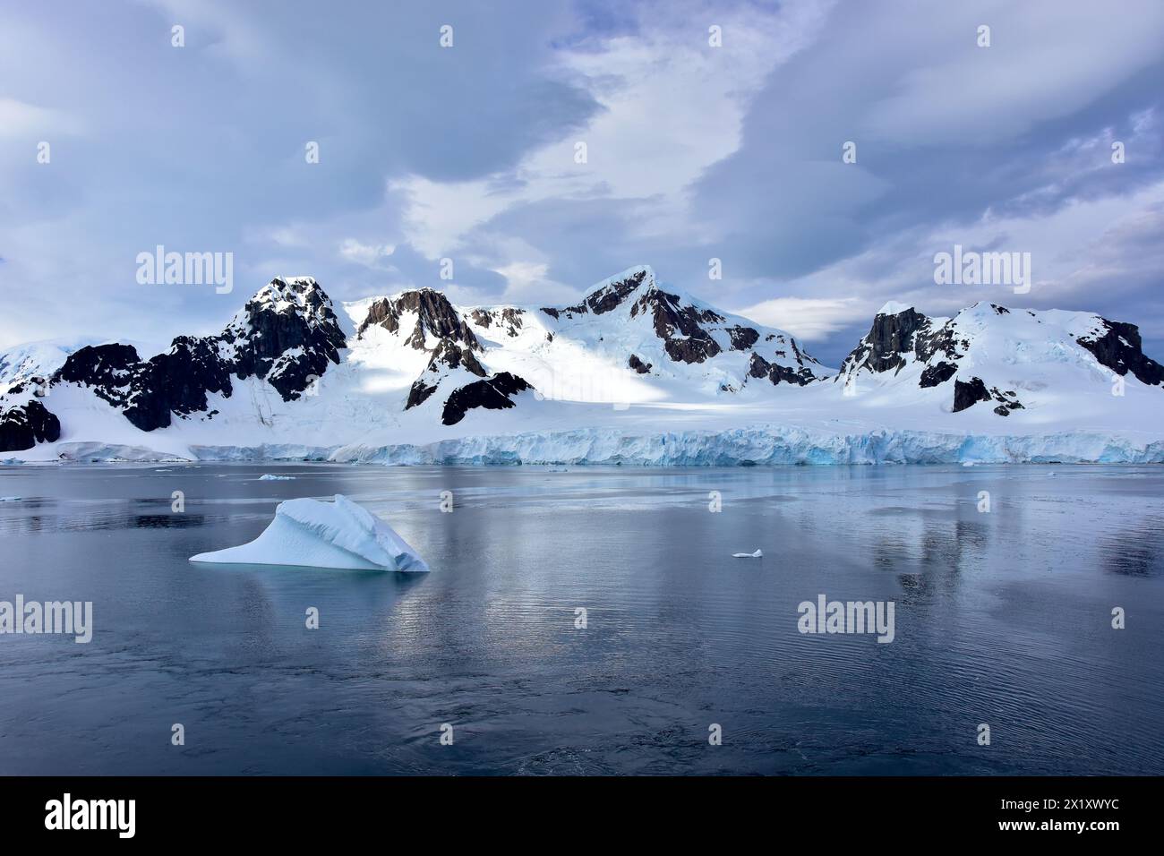 Small iceberg floating in front of land in Antarctica Stock Photo - Alamy