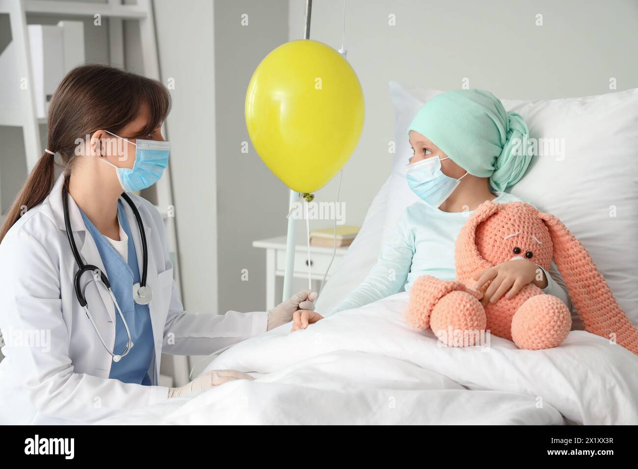 Little girl after chemotherapy receiving blue balloon from doctor in ...