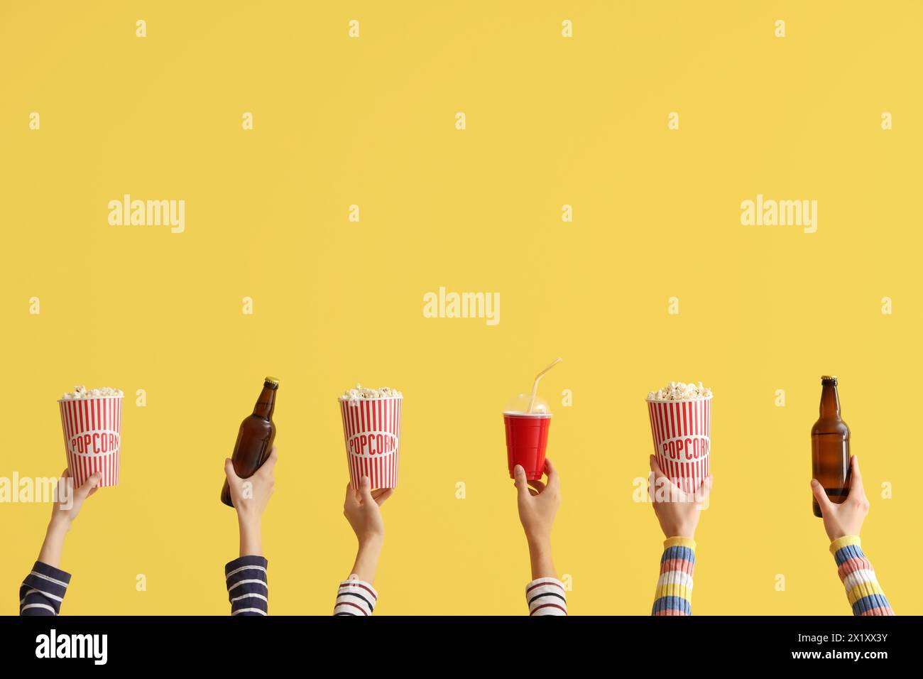 Many hands with buckets of popcorn and beer on yellow background Stock ...