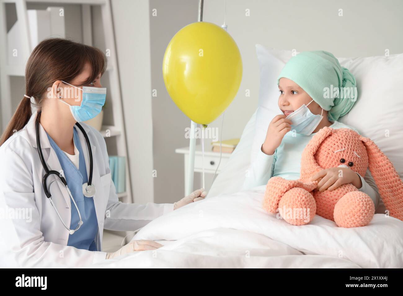 Little girl after chemotherapy receiving blue balloon from doctor in ...
