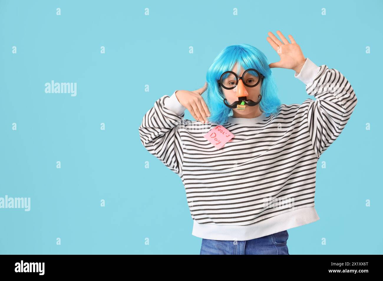 Funny little girl in disguise with party blower and sticky paper on ...