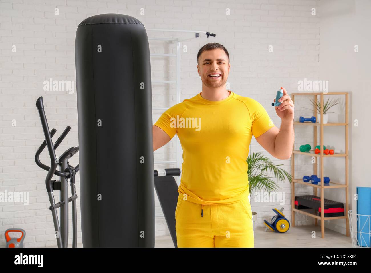 Sporty young man with inhaler near punching bag in gym Stock Photo - Alamy