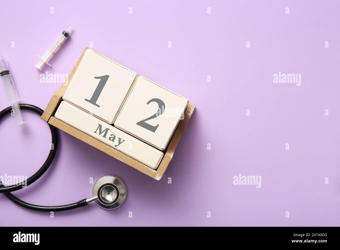 Calendar with stethoscope and syringes on lilac background ...