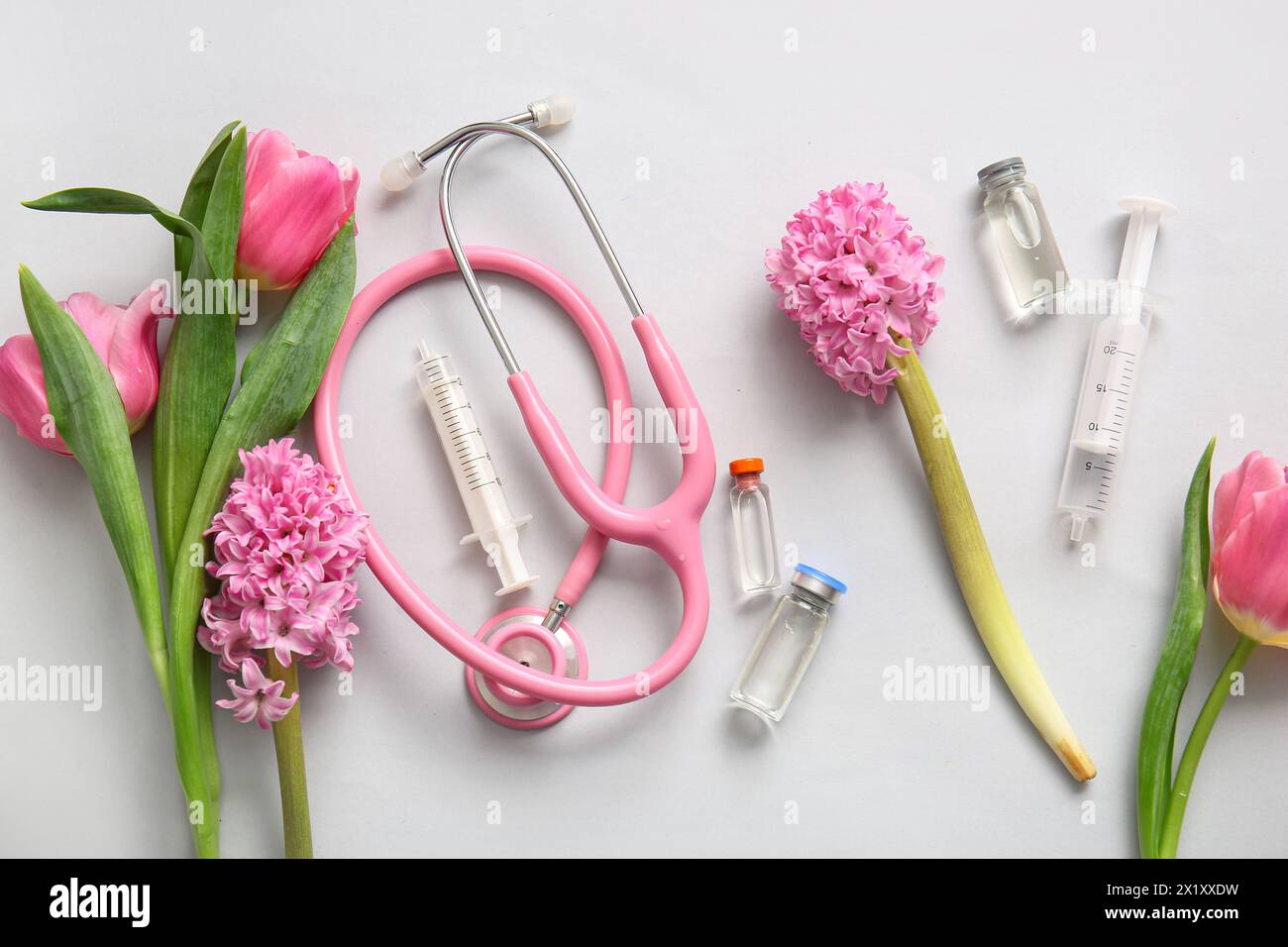 Syringe with ampules and flowers for International Nurses Day on white ...
