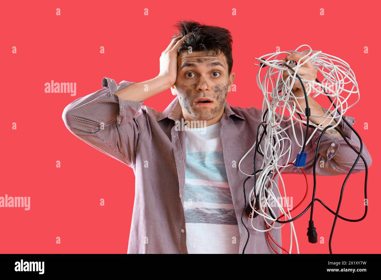 Electrocuted young man with burnt face and wires on red background ...
