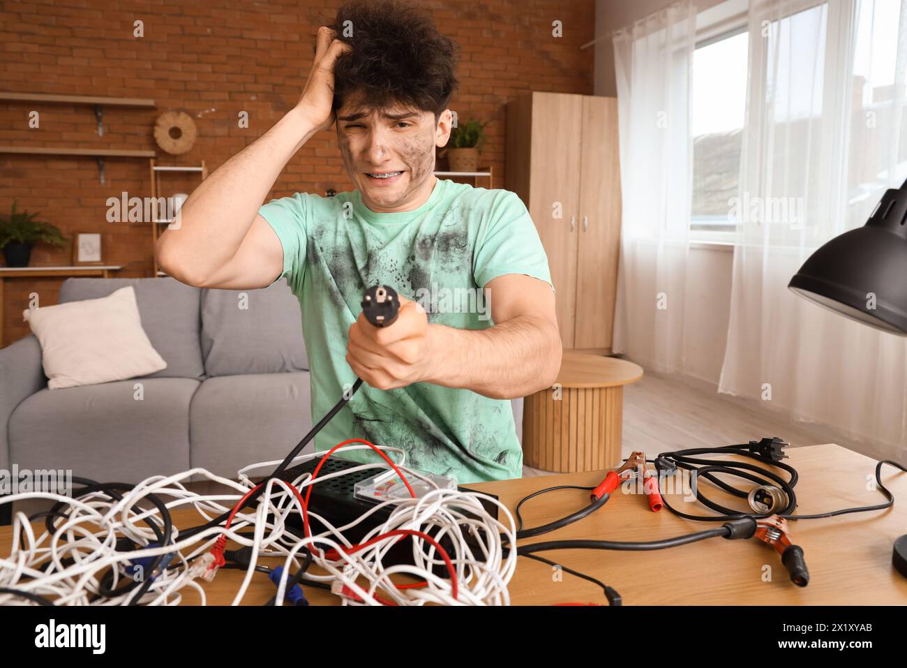 Electrocuted young man with burn face and wires on table at home Stock ...